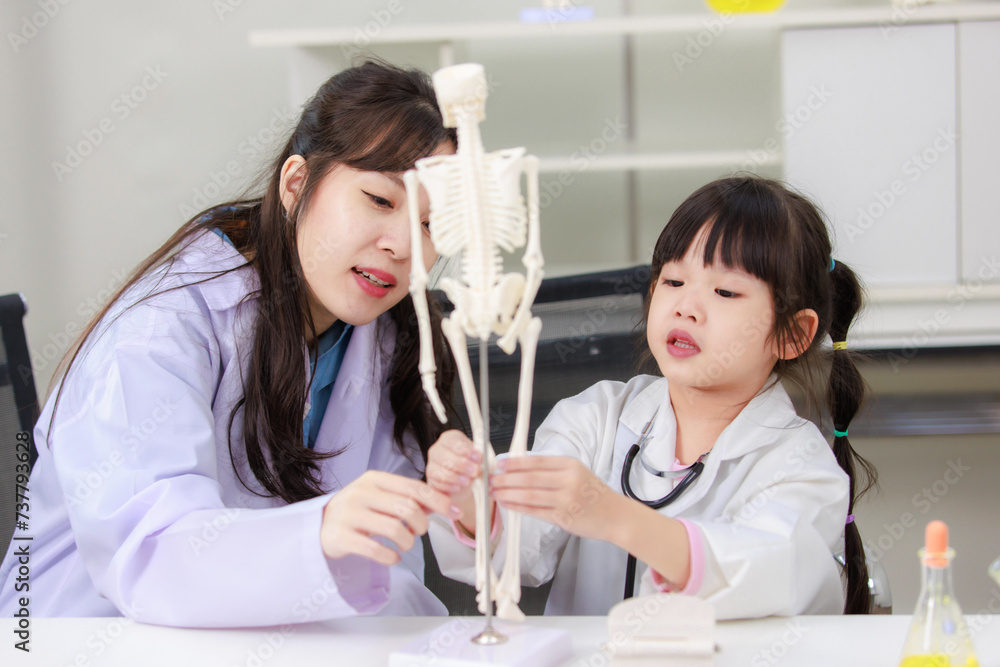 Asian woman doctor physiotherapist explains human fake skeleton hand ...