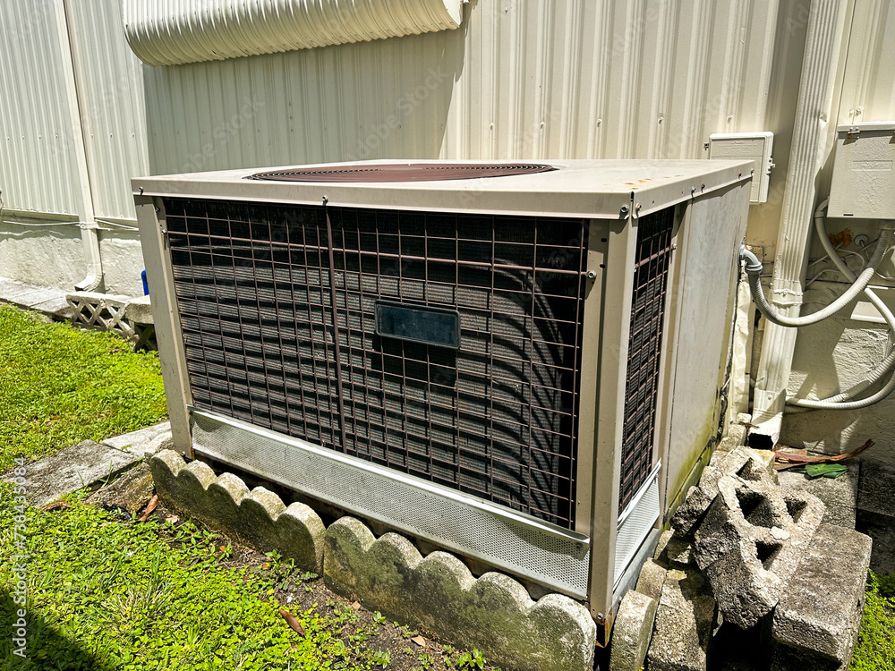 A residential outdoor air conditioning unit installed next to a mobile ...