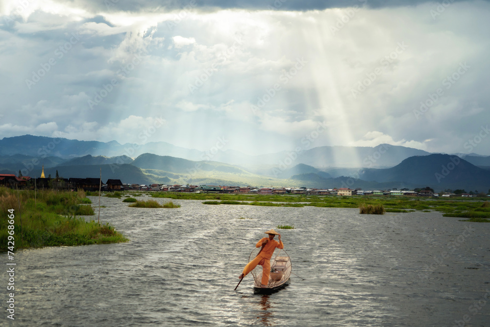 Burmese fisherman casting or throwing a net for catching freshwater ...