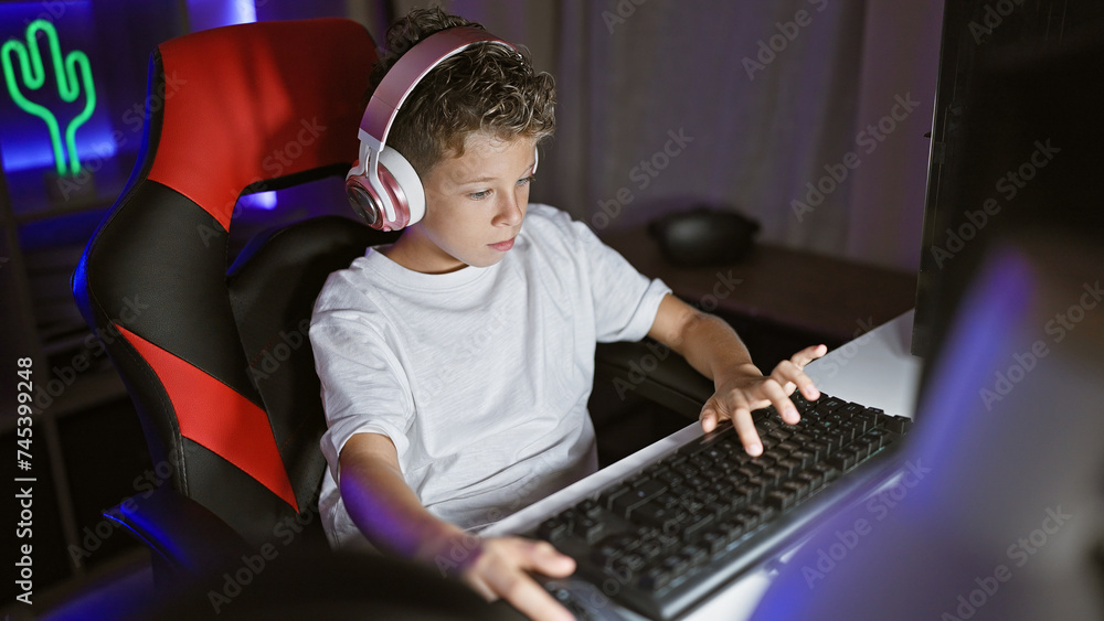 Foto Adorable blond boy streamer, engrossed playing a futuristic video ...