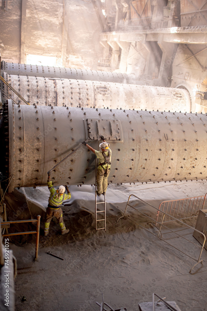 Workers are repairing the grinding mechanism in the workshop of a ...