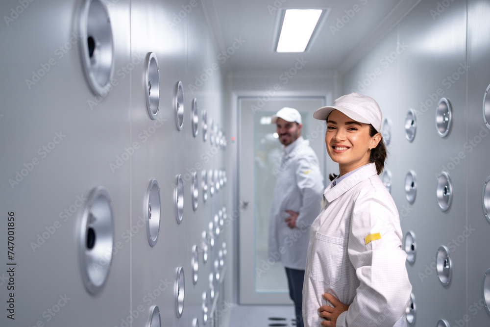Factory worker standing in industrial air blowing tunnel removing dust ...