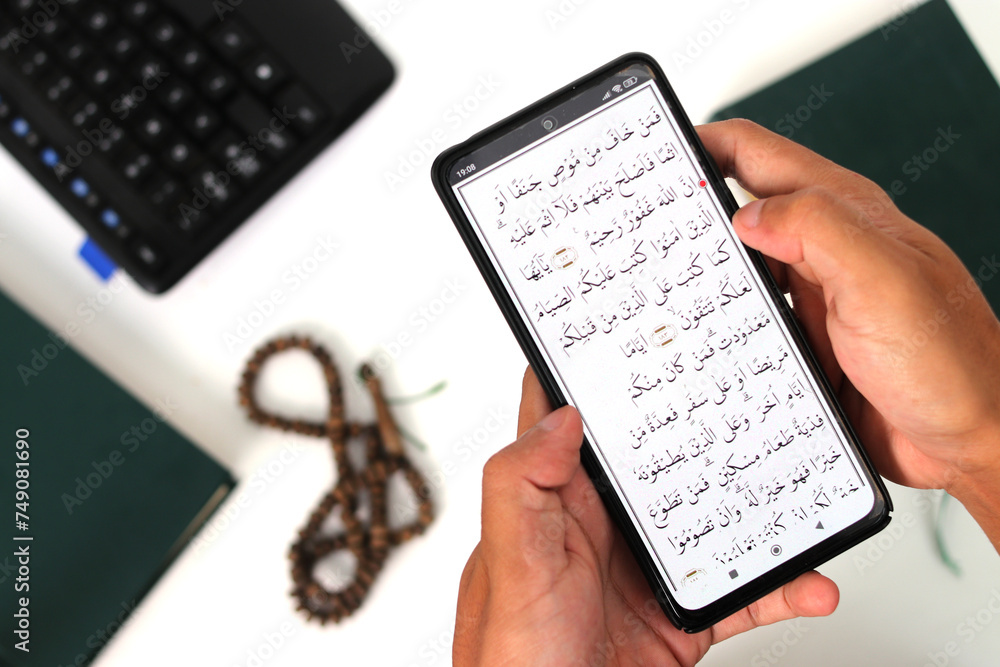 Indonesian Muslim worker taking a break to recite the Holy Quran on his ...