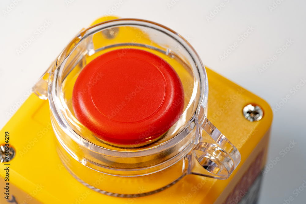 Detailed close-up of the upper part of a red emergency stop button with ...