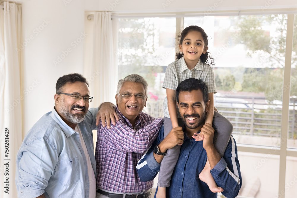 Happy young Indian dad holding little daughter kid on shoulders ...