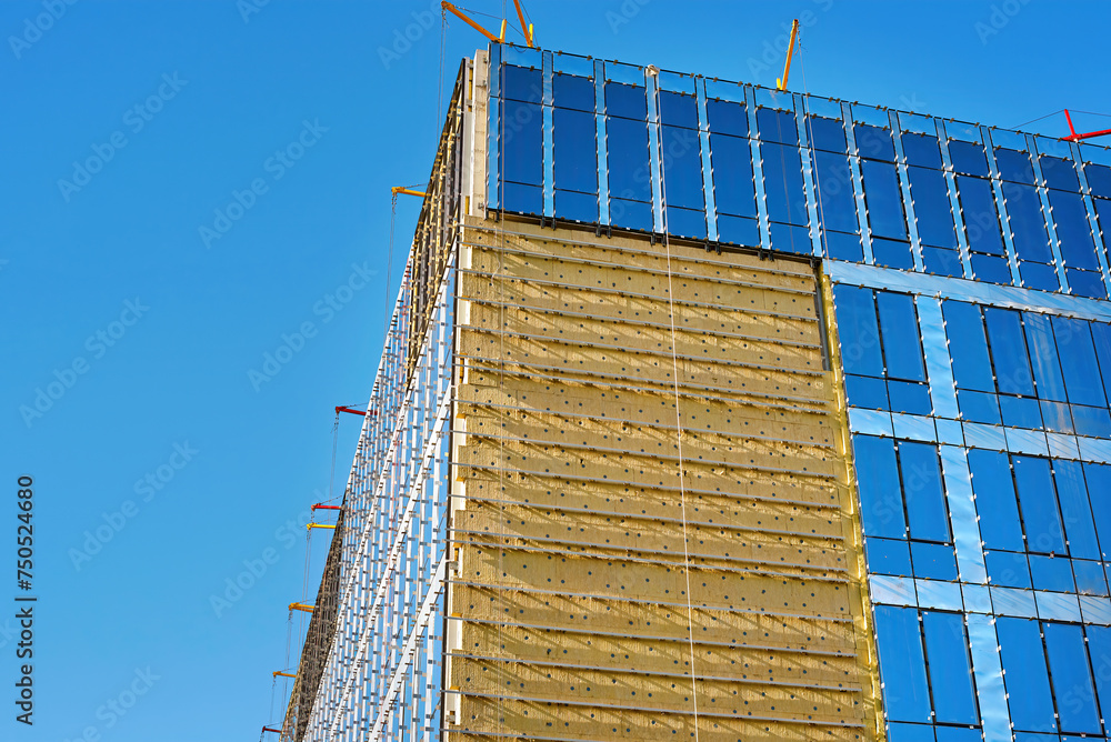 Mineral wool insulation of building, facade glazing work. Thermal ...