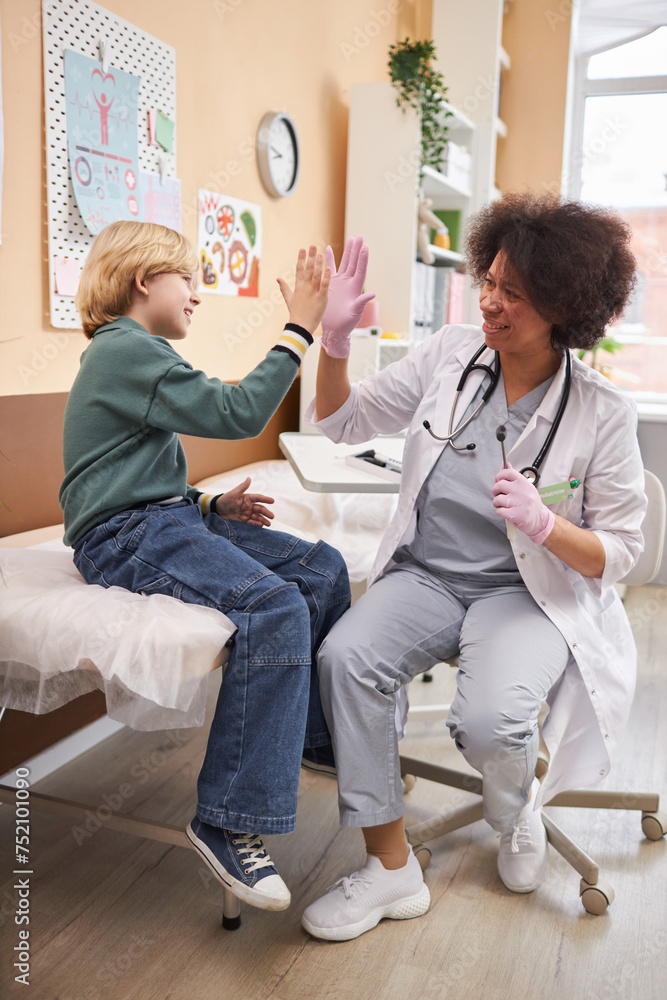 Vertical full length portrait of happy little boy high five with female ...