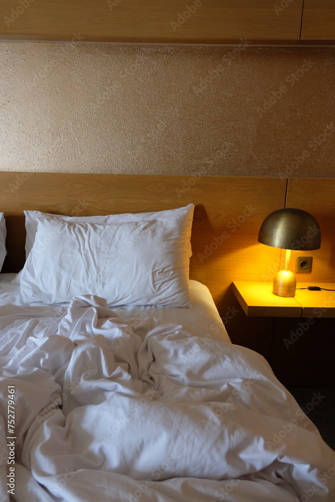 Selective focused of messy bedroom with lamp near bed. Wrinkled bed ...