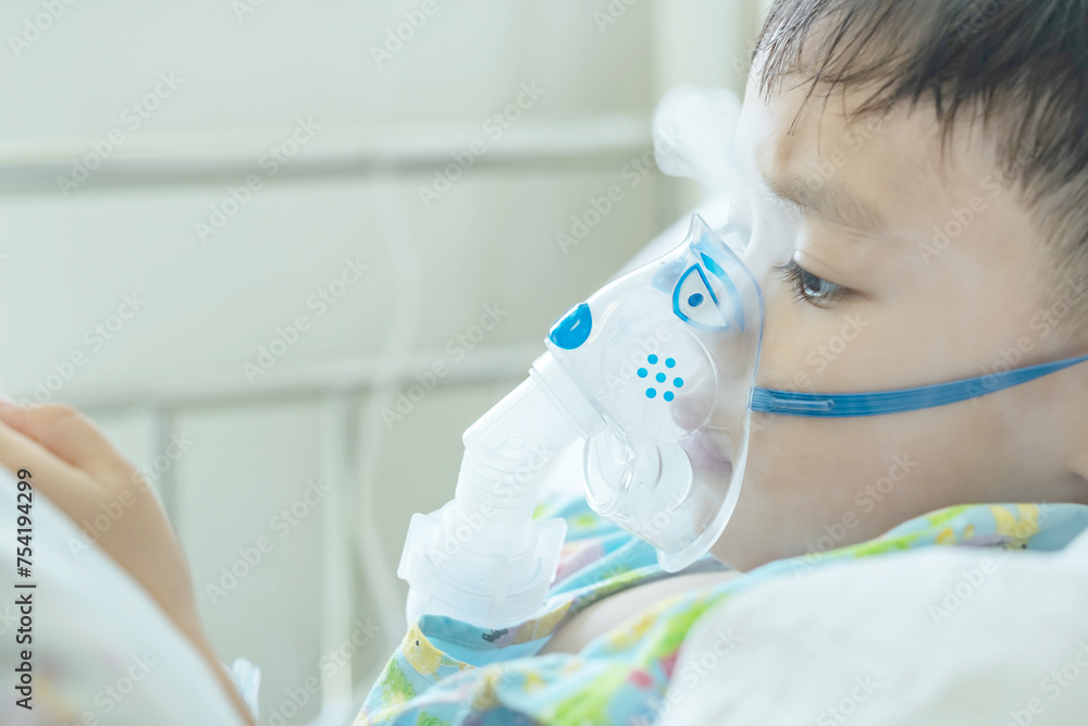 Little asian boy making inhalation with nebulizer at hospital ...