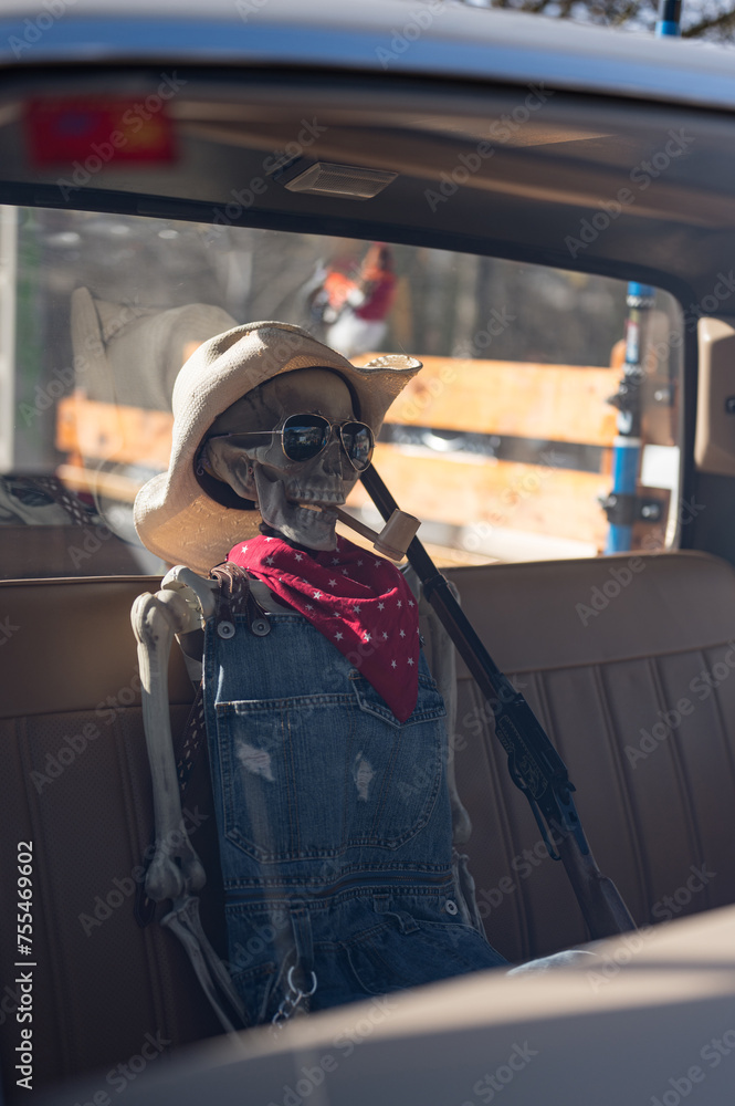 Detail of a skeleton dressed as a farmer with a straw hat and a lever ...