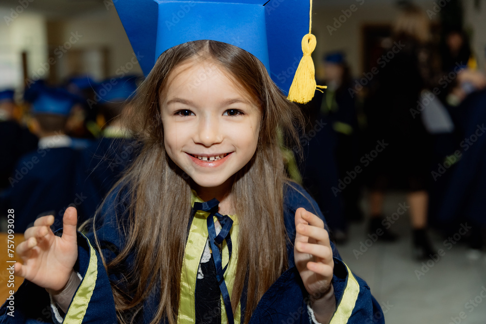 a very joyful and happy little girl in a first grader's uniform smiles ...