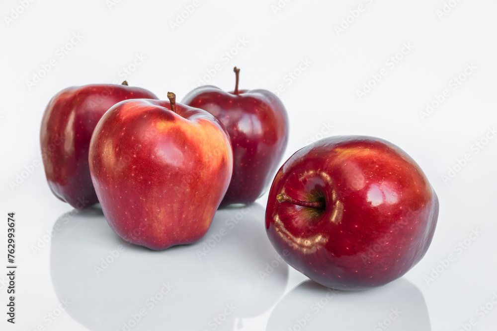 Four Red Delicious (Red Chief) apples with the closest one lying on its ...