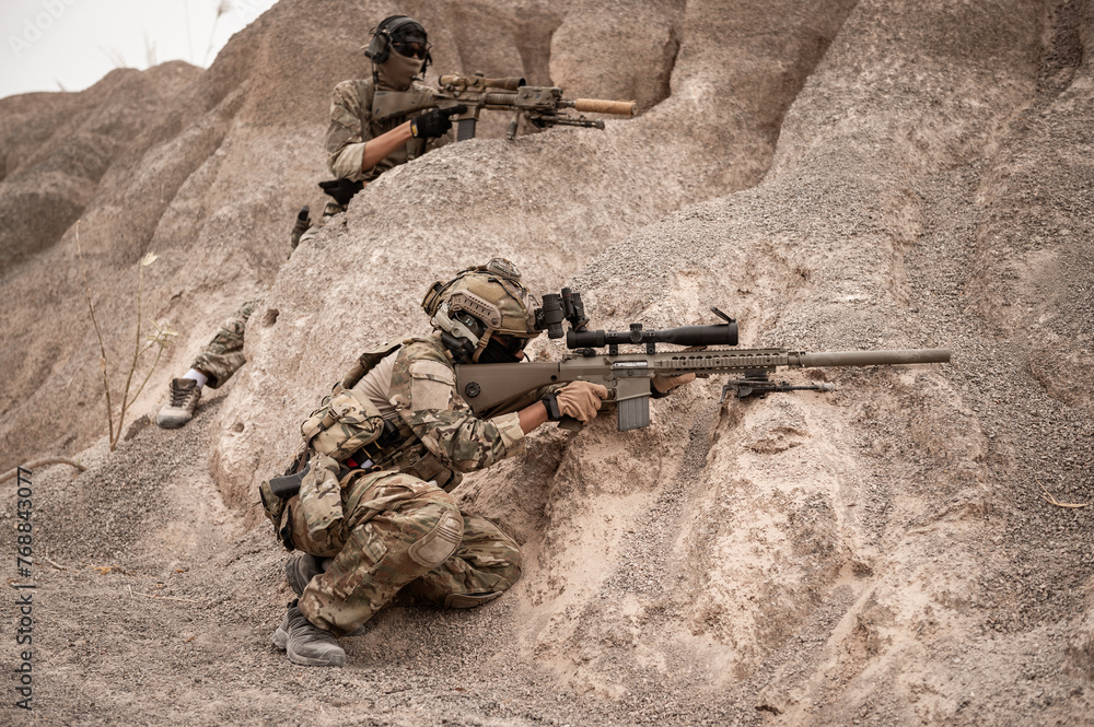 Soldiers in camouflage uniforms aiming with their rifles.ready to fire ...