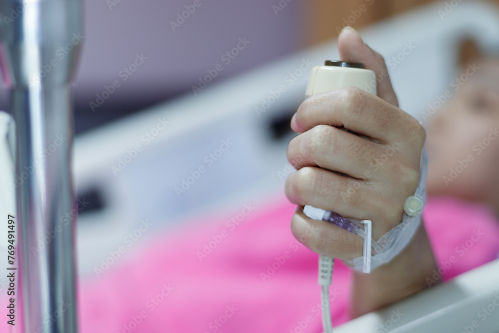 patient's hand presses a help button to call a nurse in an emergency. A ...