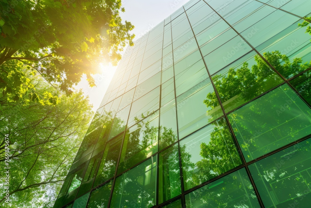 Green glass building with sunlight and tree background, sustainable ...