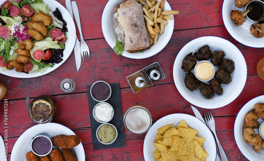 Top view of the restaurant table with drinks and many gourmet dishes ...
