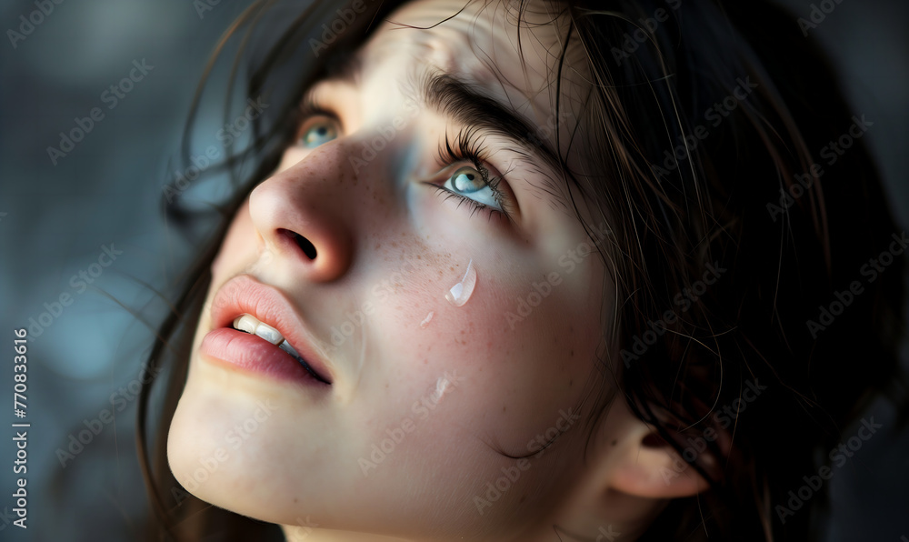 Young woman looking up praying to God with tears in eyes, being touched ...