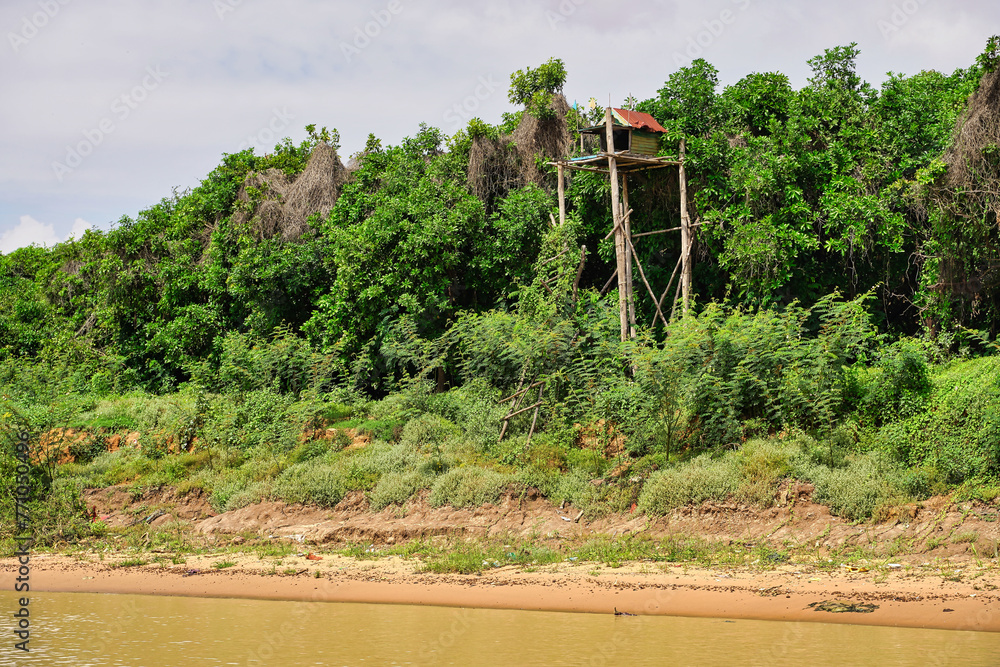 Huts built on long stilts to avoid floods at Siem Reap river near Tonle ...
