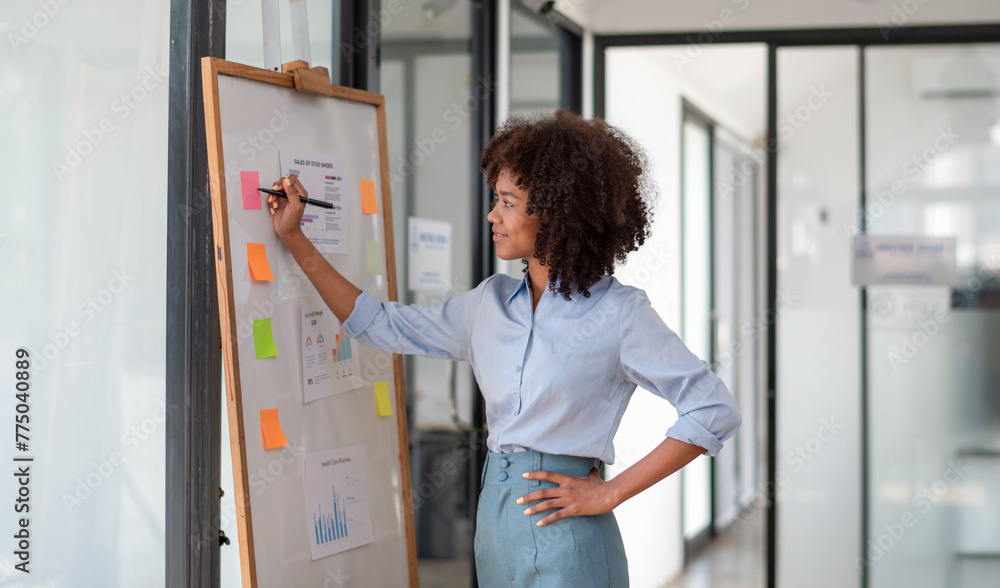 African American woman taking notes, writing in notebook, planning ...