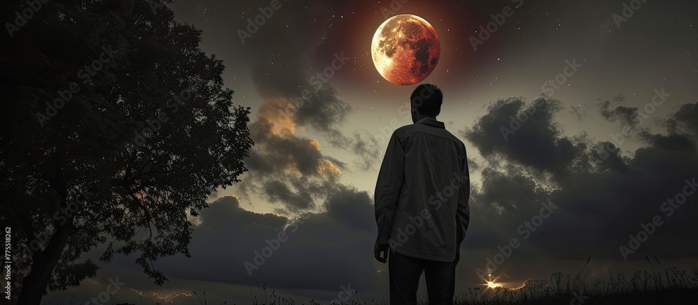 A man poses with the lunar eclipse behind him 🌒📸 Capturing the awe of ...