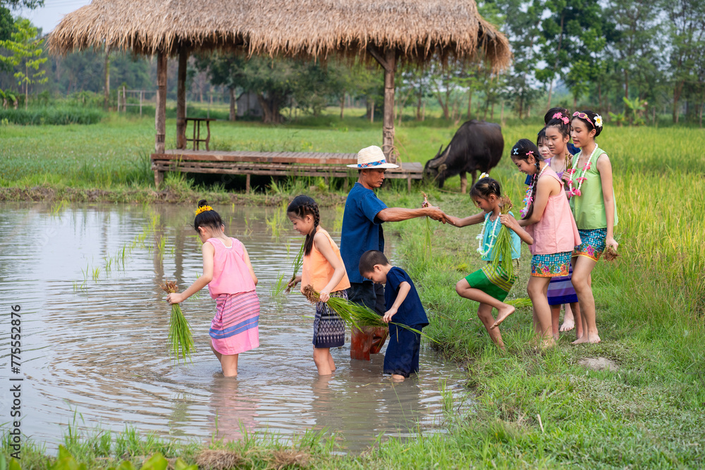 Thai children wear traditional farmer outfits to learn about the ...