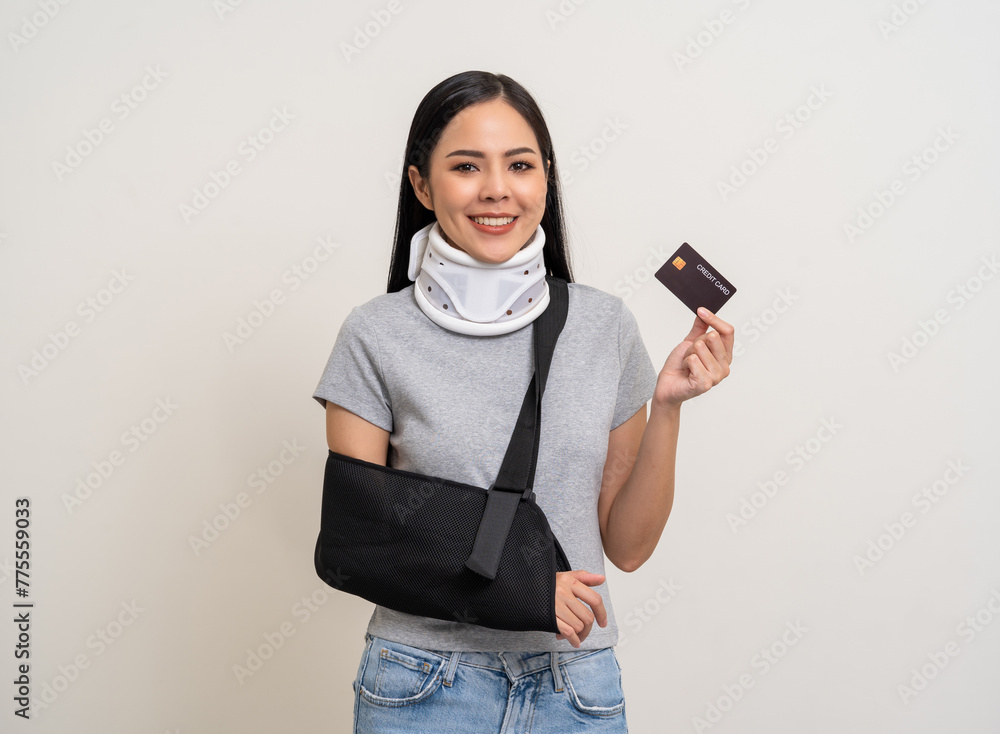Asian woman broken arm and leg holding credit card payment. Woman put on plaster cast splint ...