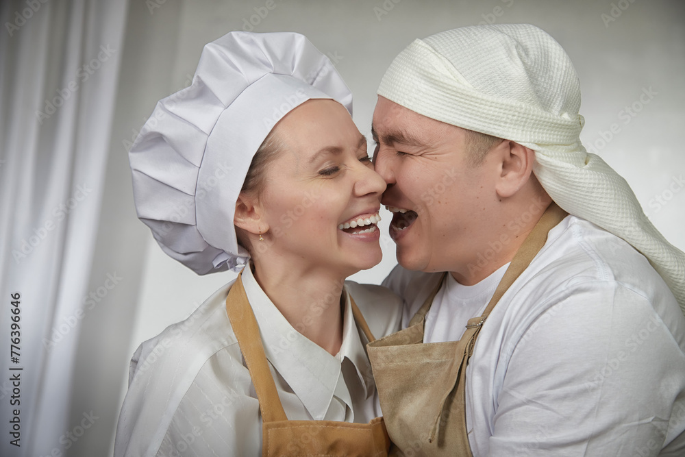 Cute oriental family with wife and husband cooking in the kitchen on ...
