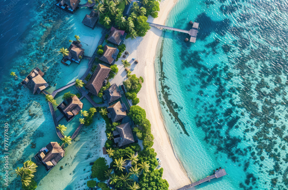 An aerial view of an island in the Maldives with overwater bainment and ...