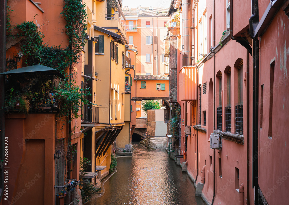 Iconic canal street in Bologna with colorful orange and yellow houses ...