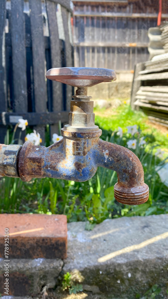 Rusty old water tap close up photography in a garden in the countryside ...