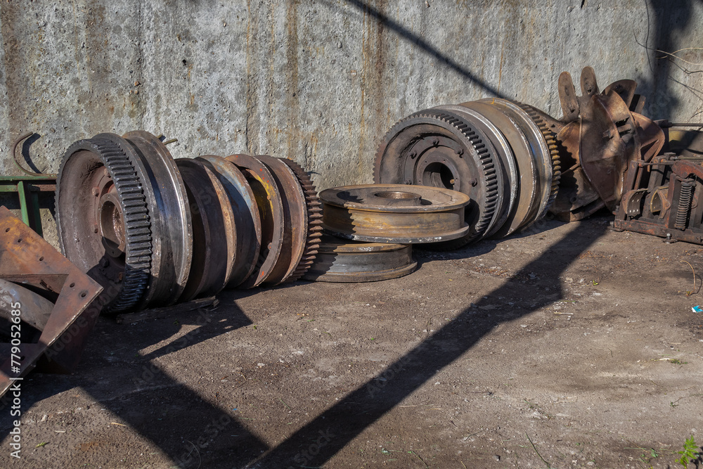 old rusty metal wheels from a crane lying in a row against the ...