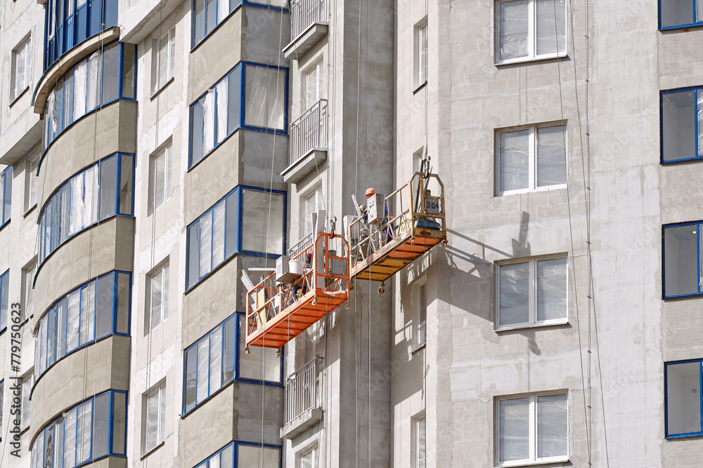 Window sill installation, new building construction. Workers using lift ...