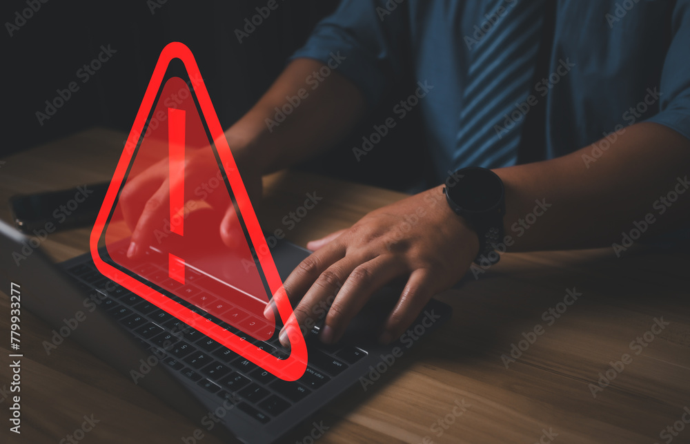 Hacker or programmer using laptop with triangle caution warning sign, coding, cryptography ...