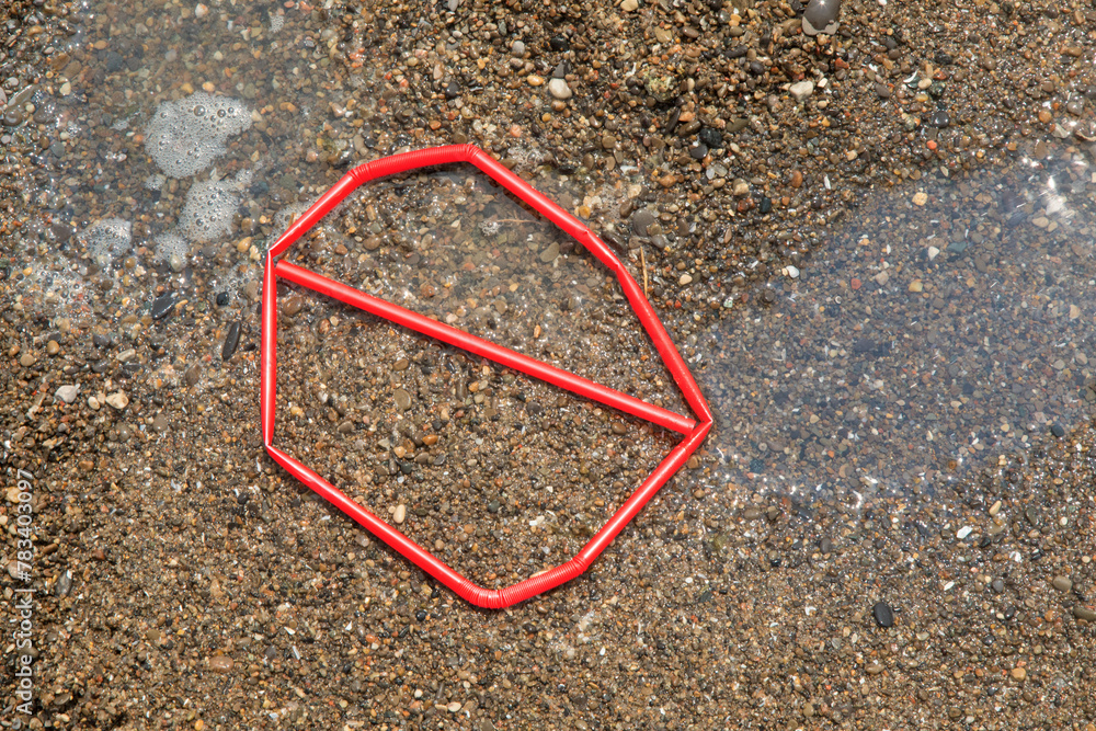 colorful plastic single use straw waste washed up on the beach forming ...