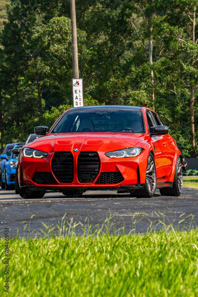 Red luxury sportscar on race track, BMW M3 Competition in car meet ...