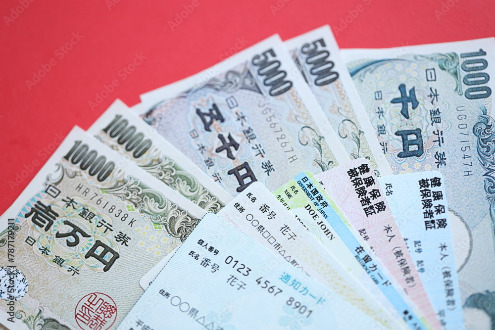 Light blue and red Japan Health Insurance cards on table with japanese ...