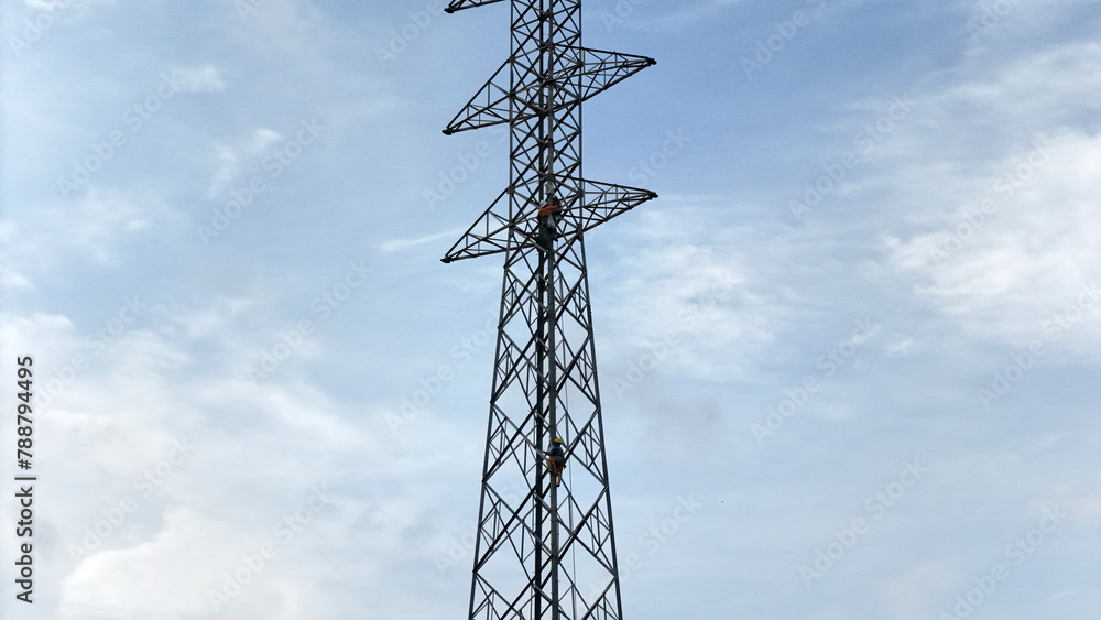 construction of electric pylons. people climbing power towers to erect ...