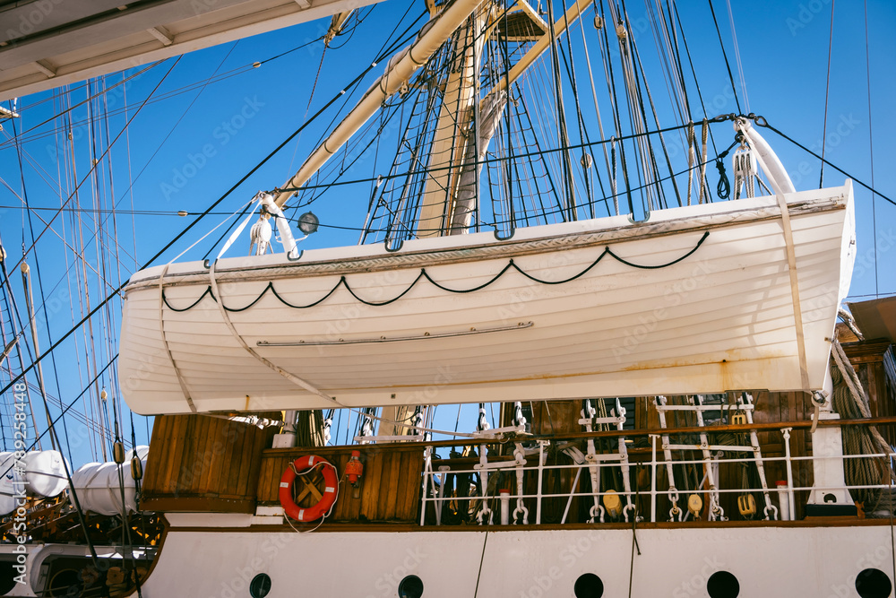 Lifeboat on sailing ship deck, clear blue sky background. Features ...