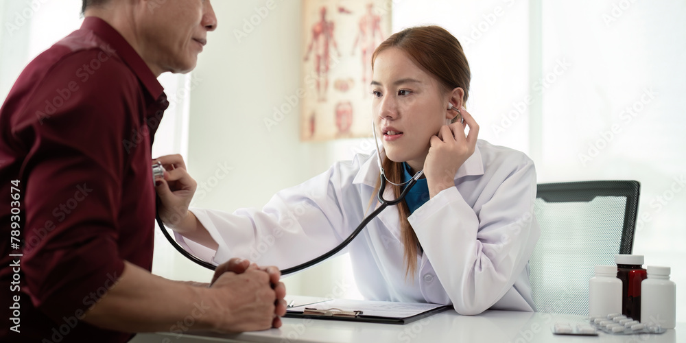 Female doctor asian cardiologist examining senior male cardiac patient ...