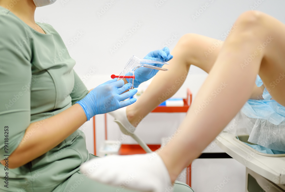 Gynecologist examines a patient laying on gynecological chair using ...