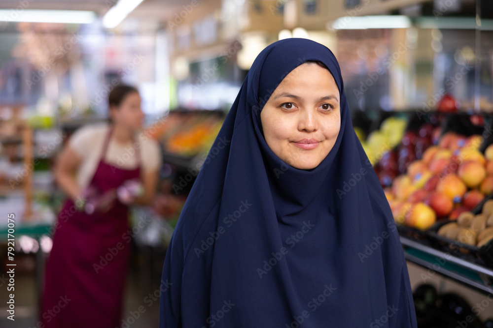 Stock-Foto „Young housewife in hijab stands in grocery supermarket and ...