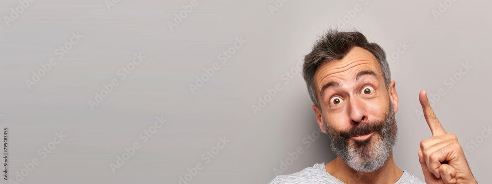 Mature man with a surprised expression and finger pointing upwards ...