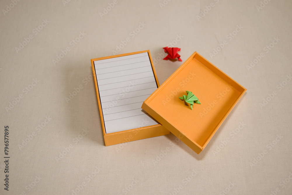 orange cardboard box with tearing notepads with lines, lid and two ...