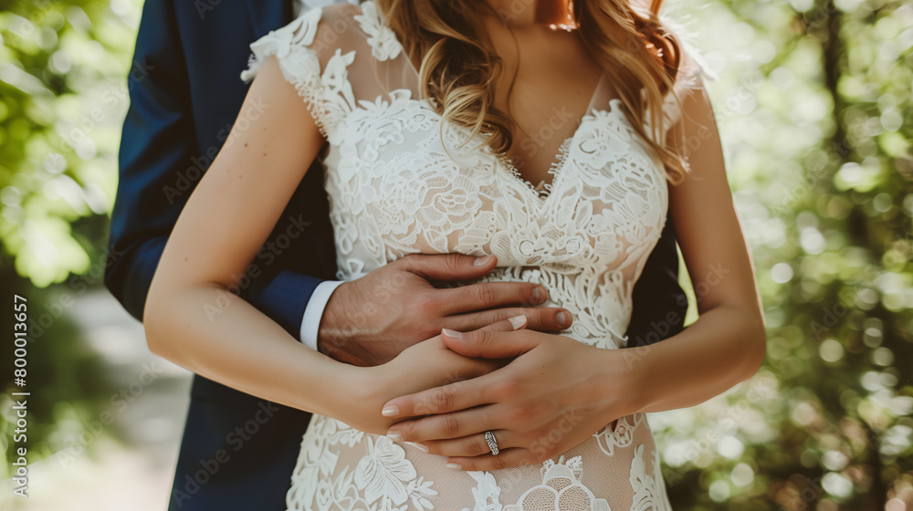Close-up of a pregnancy mom belly is hugged by her husband. The groom ...