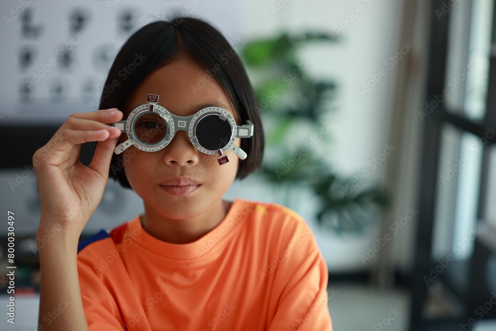 Elementary school girl wearing eyeglasses visual acuity test with test ...