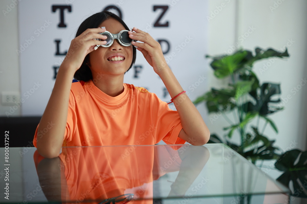 Elementary school girl wearing eyeglasses visual acuity test with test ...