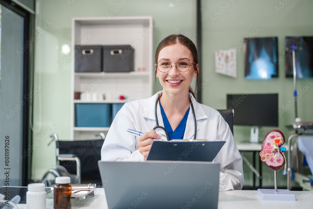 Caucasian woman sits at a desk, kidney model, gallstones ...