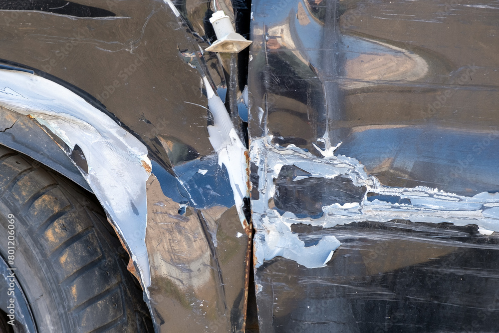 Deep dents, scratches with chipped paint on the door and fender of the ...