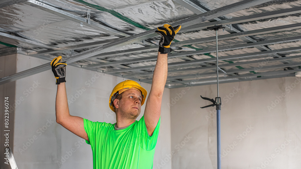 Plasterboard worker making a plasterboard ceiling. Assembling the ...