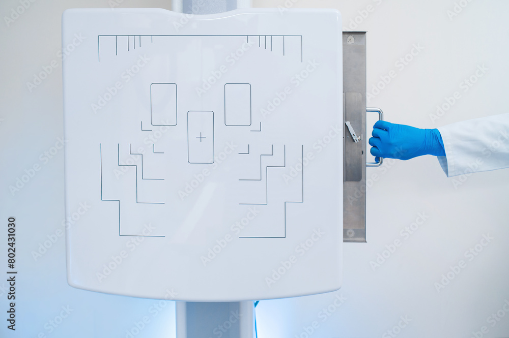 white wall with drawing of an X-ray machine. A doctor's hand in medical ...
